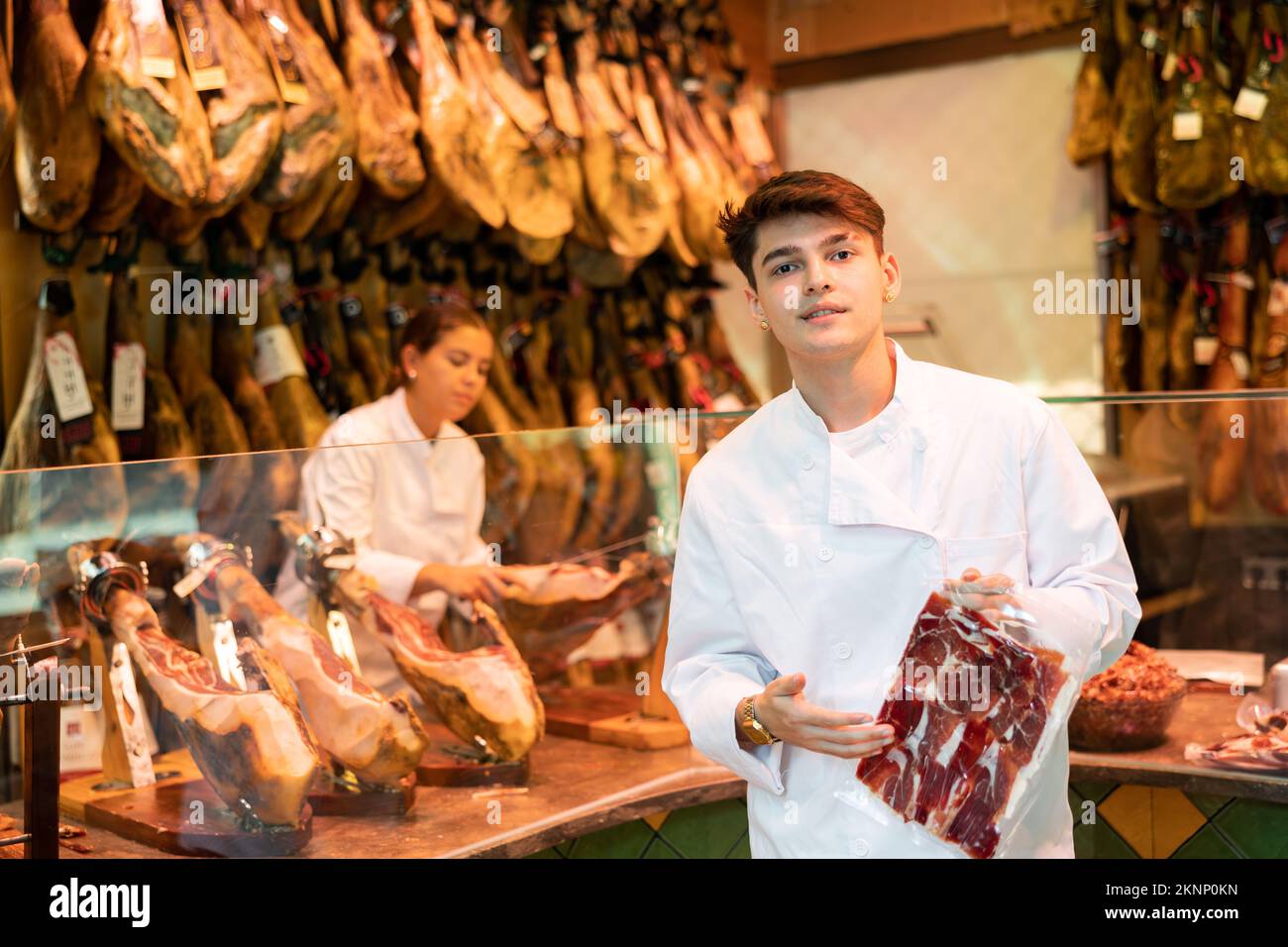 Male seller offering sliced bacon in butcher shop Stock Photo - Alamy