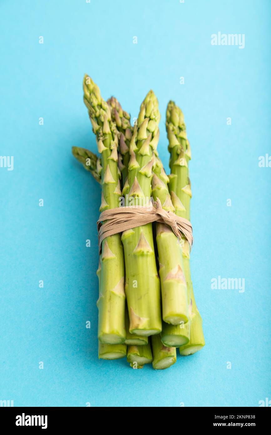 Bunch of fresh green asparagus on blue pastel background. Side view ...