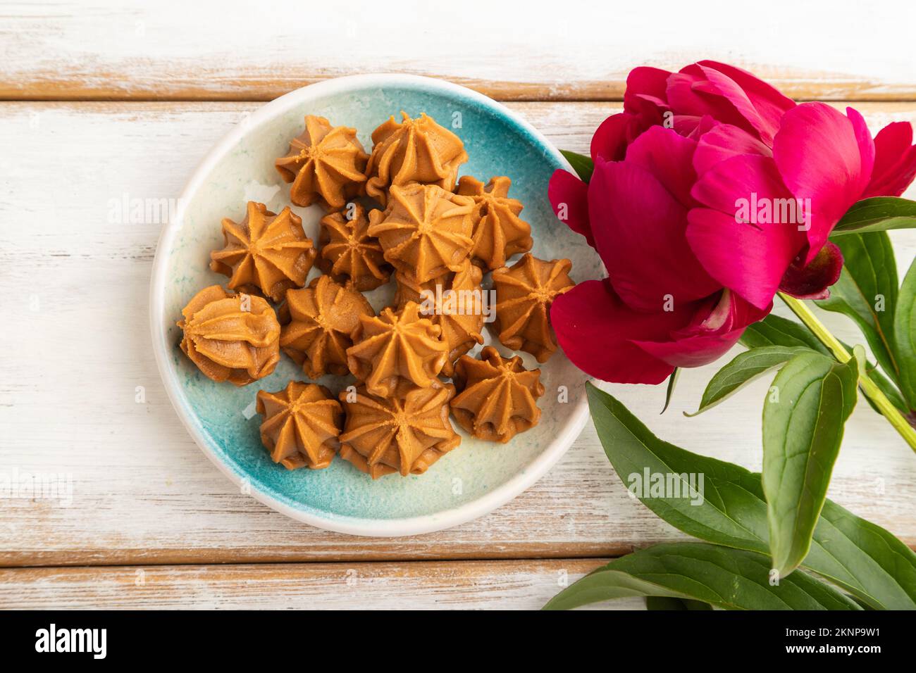 Homemade soft caramel fudge candies on blue plate on white wooden ...