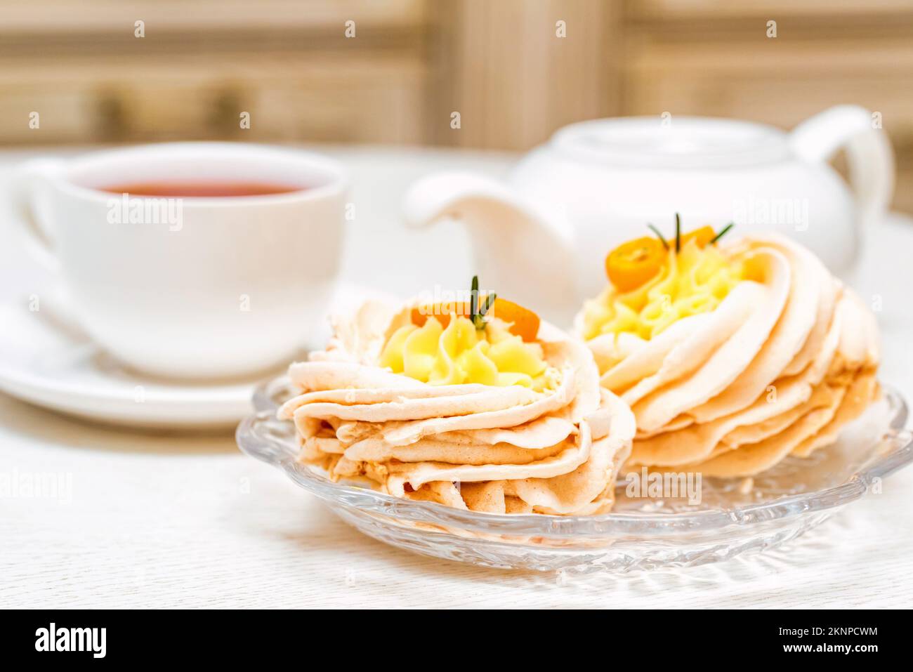 Meringue cake decorated with kumquat and tea Stock Photo - Alamy