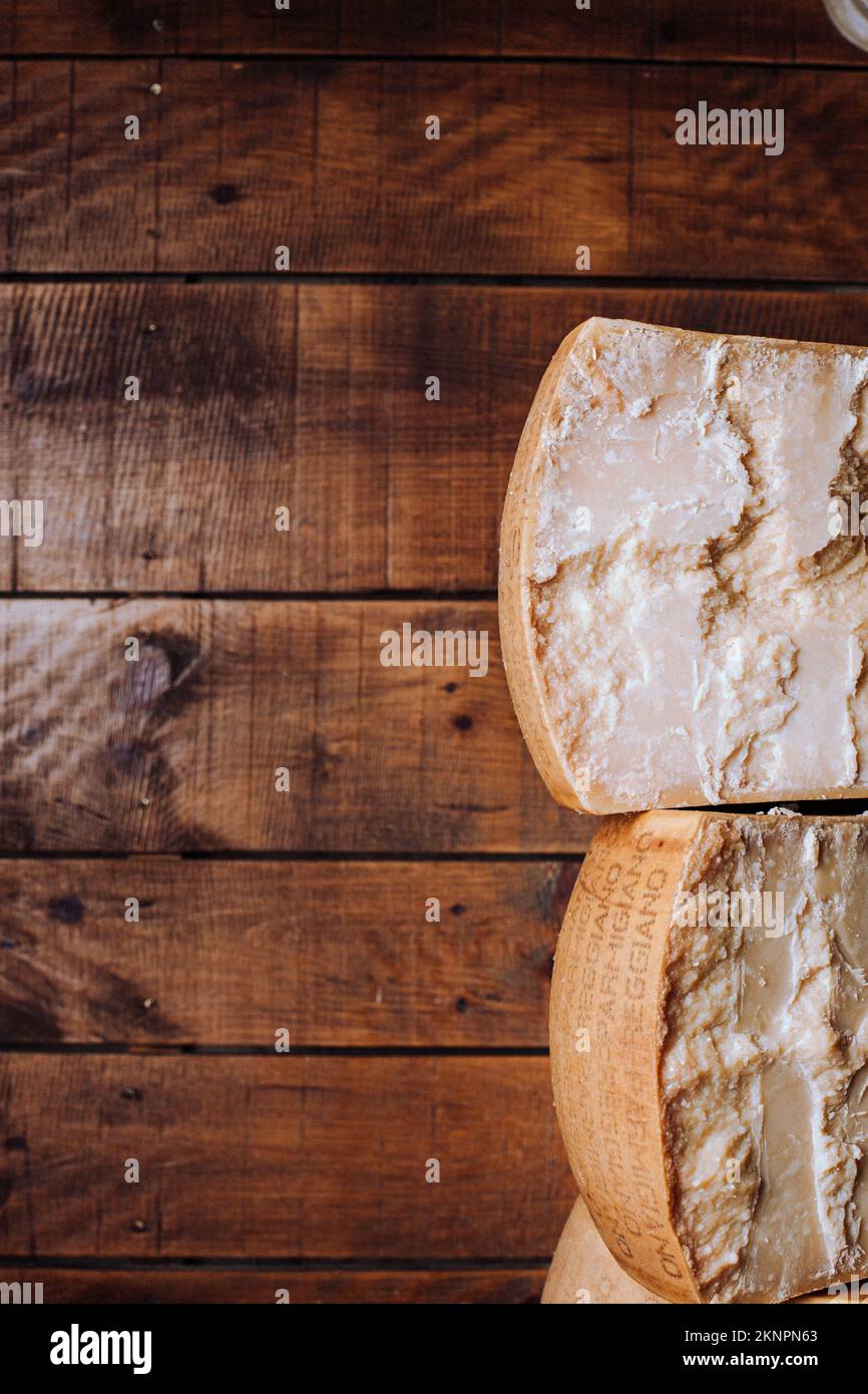 A vertical top view of Parmesan cheese slices on an empty wooden ...