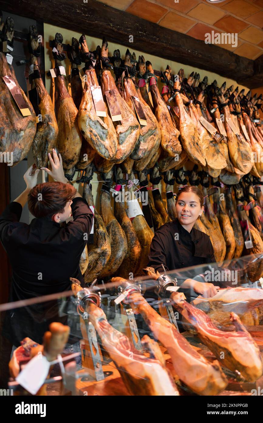 Young couple work together in butcher shop - they cut traditional ...