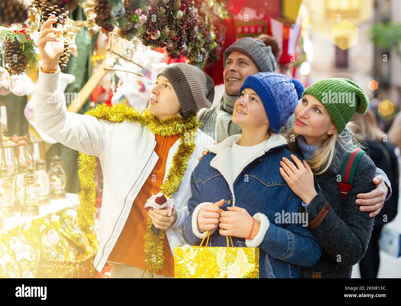 Family of four choosing decorations at Christmas fair Stock Photo - Alamy