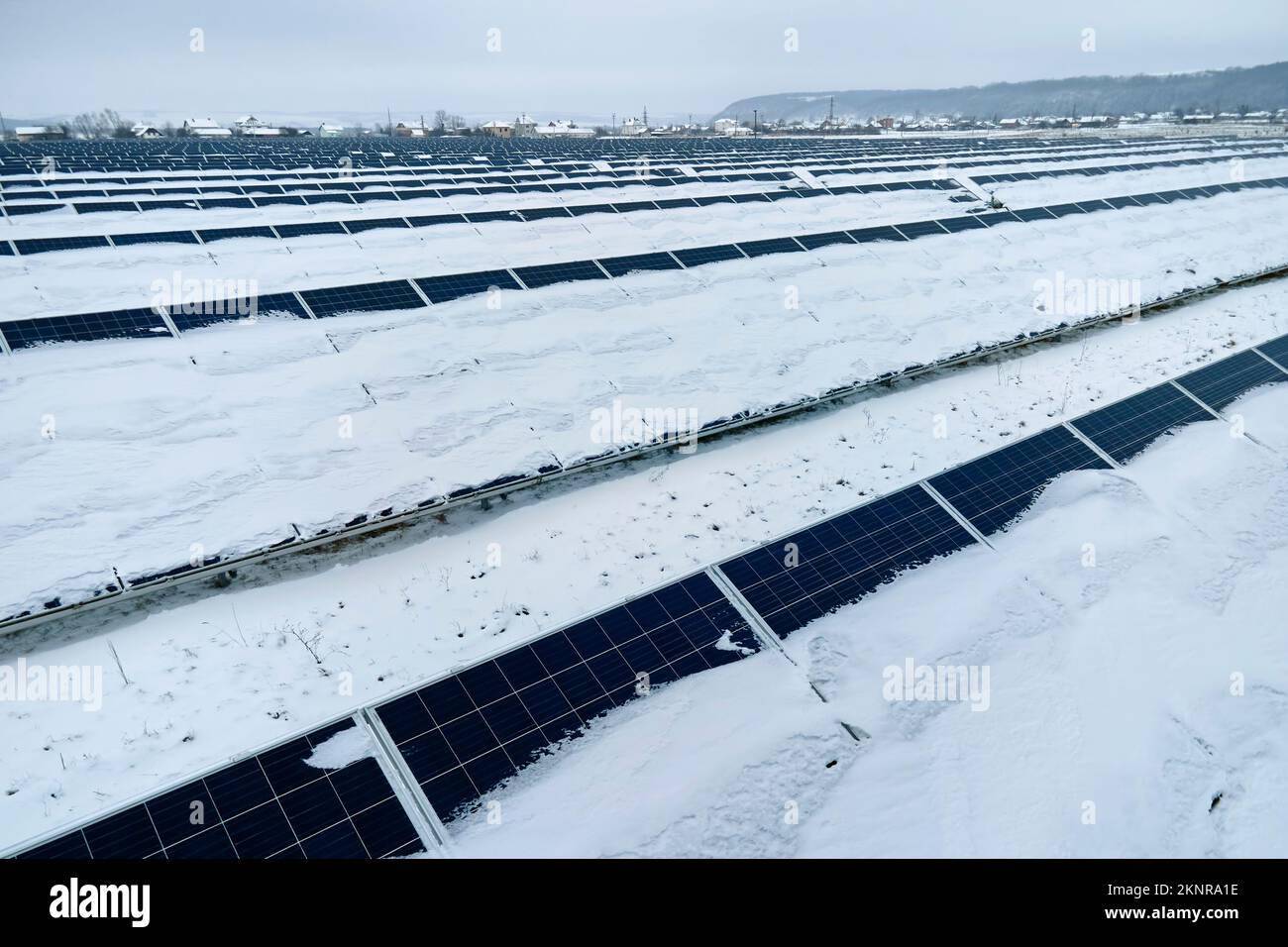 Aerial view of snow covered sustainable electric power plant with rows ...