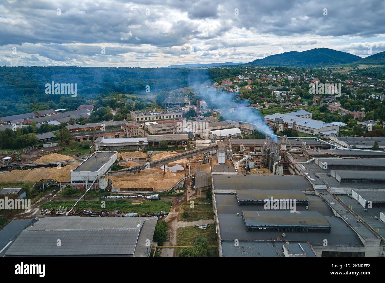 Aerial view of wood processing plant with smokestack from production ...