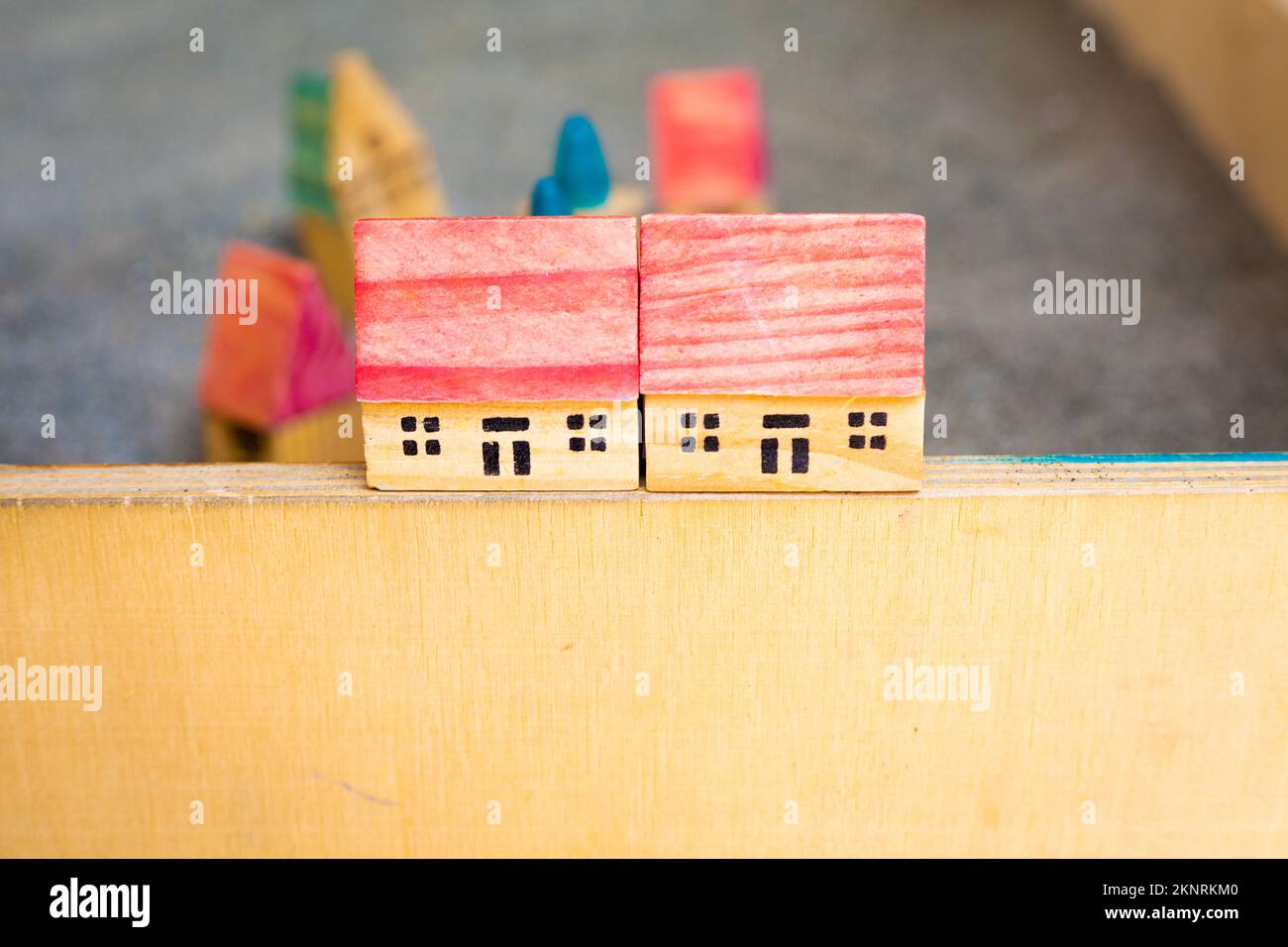 TwoCottages with red roof on grey soil. small wooden toy houses on ...