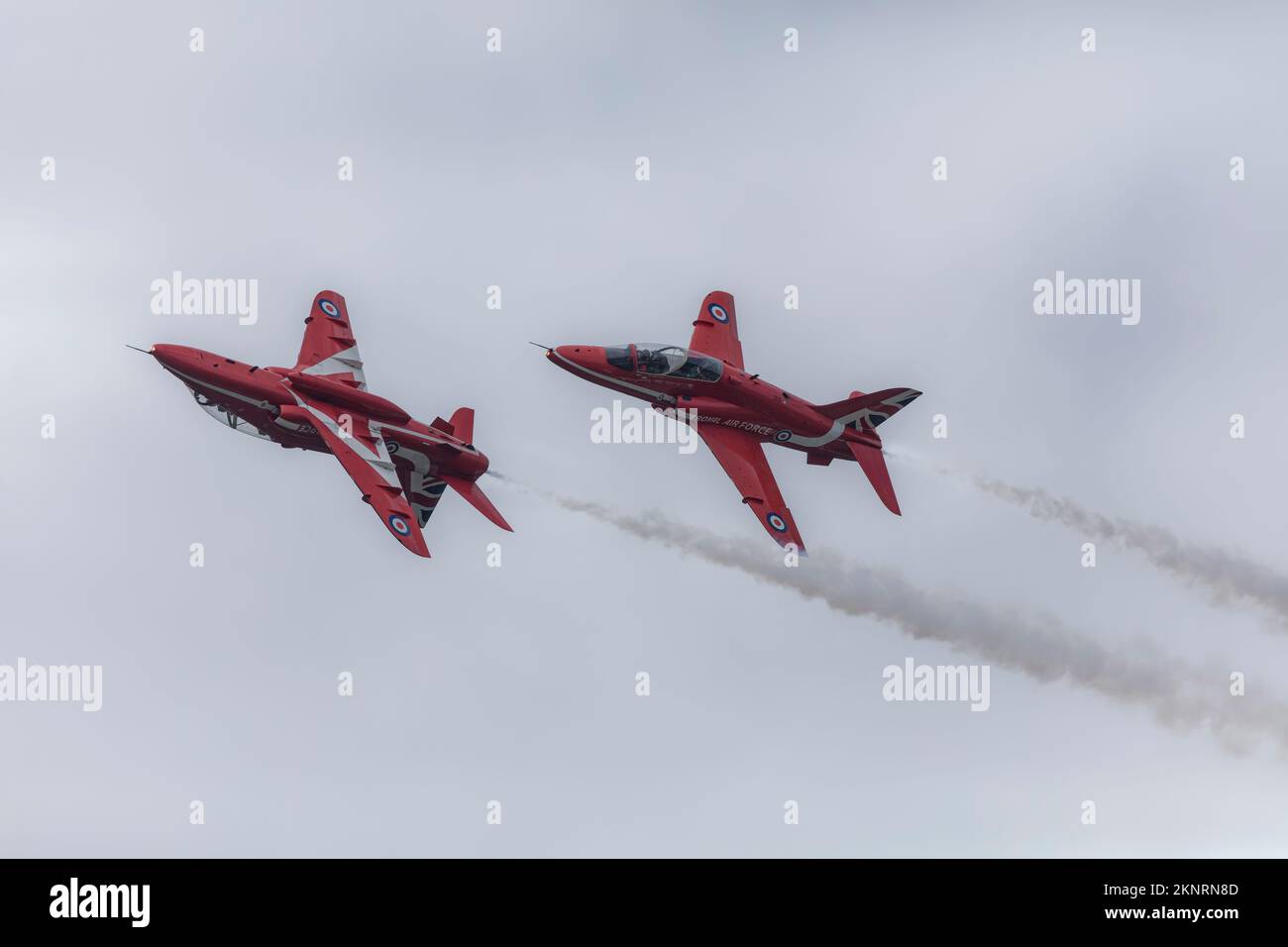 Two RAF Red Arrow Hawk Jets in flight with smoke trails on plain white background Stock Photo ...