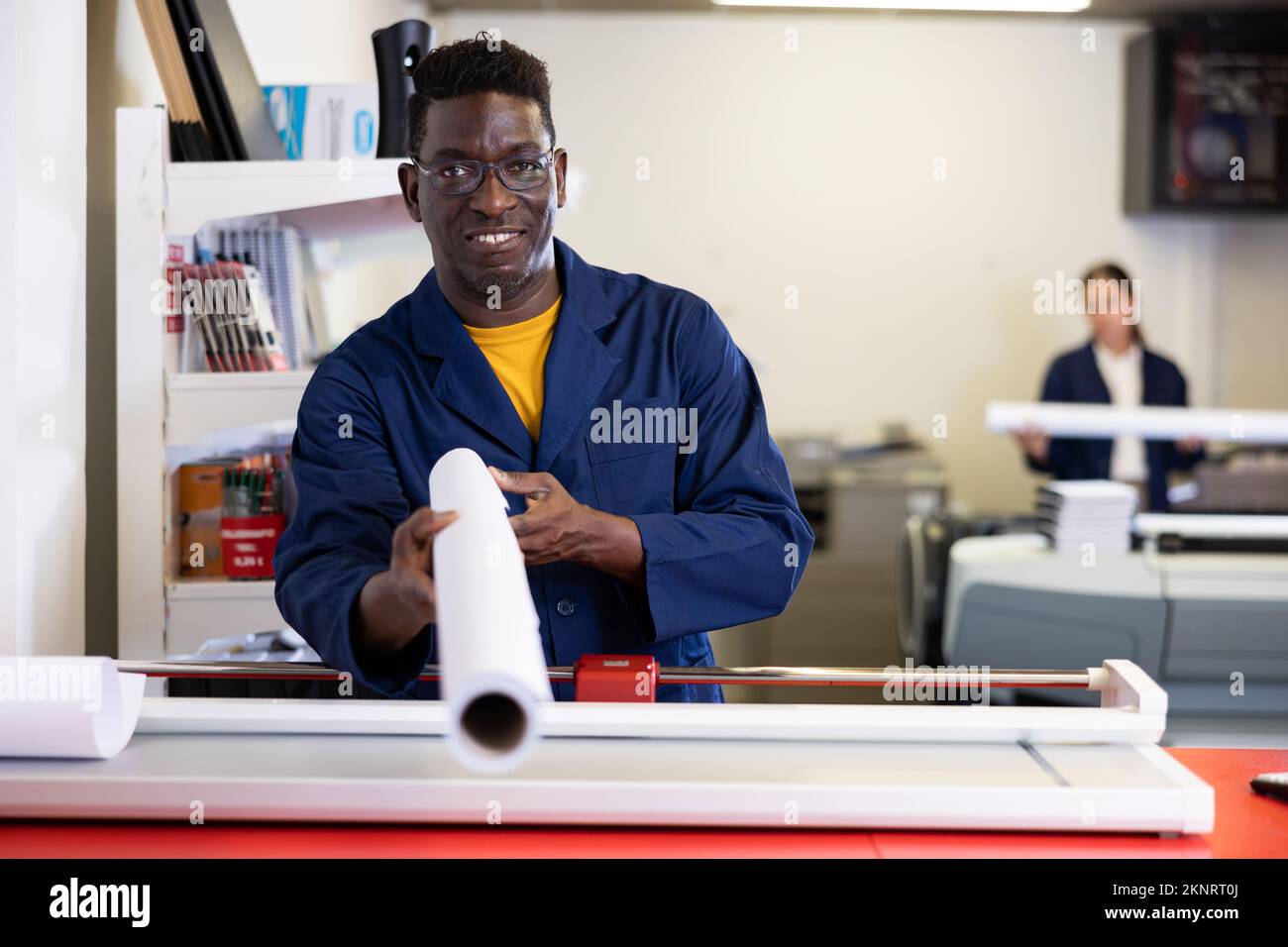 Excited middle-aged African American male typographer in uniform ...