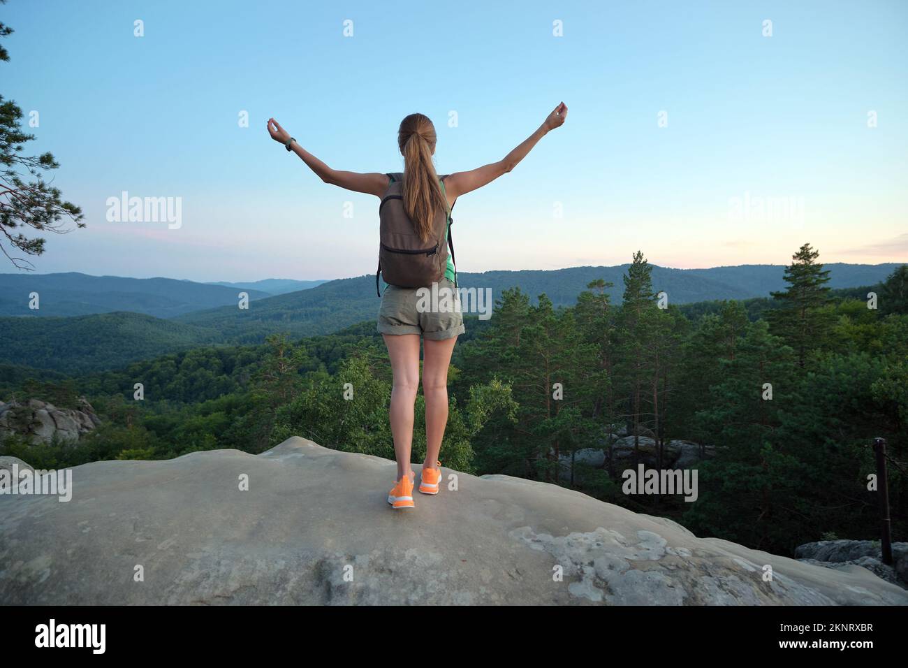 Hiker woman relaxing on mountain footpath raising up hands enjoying ...