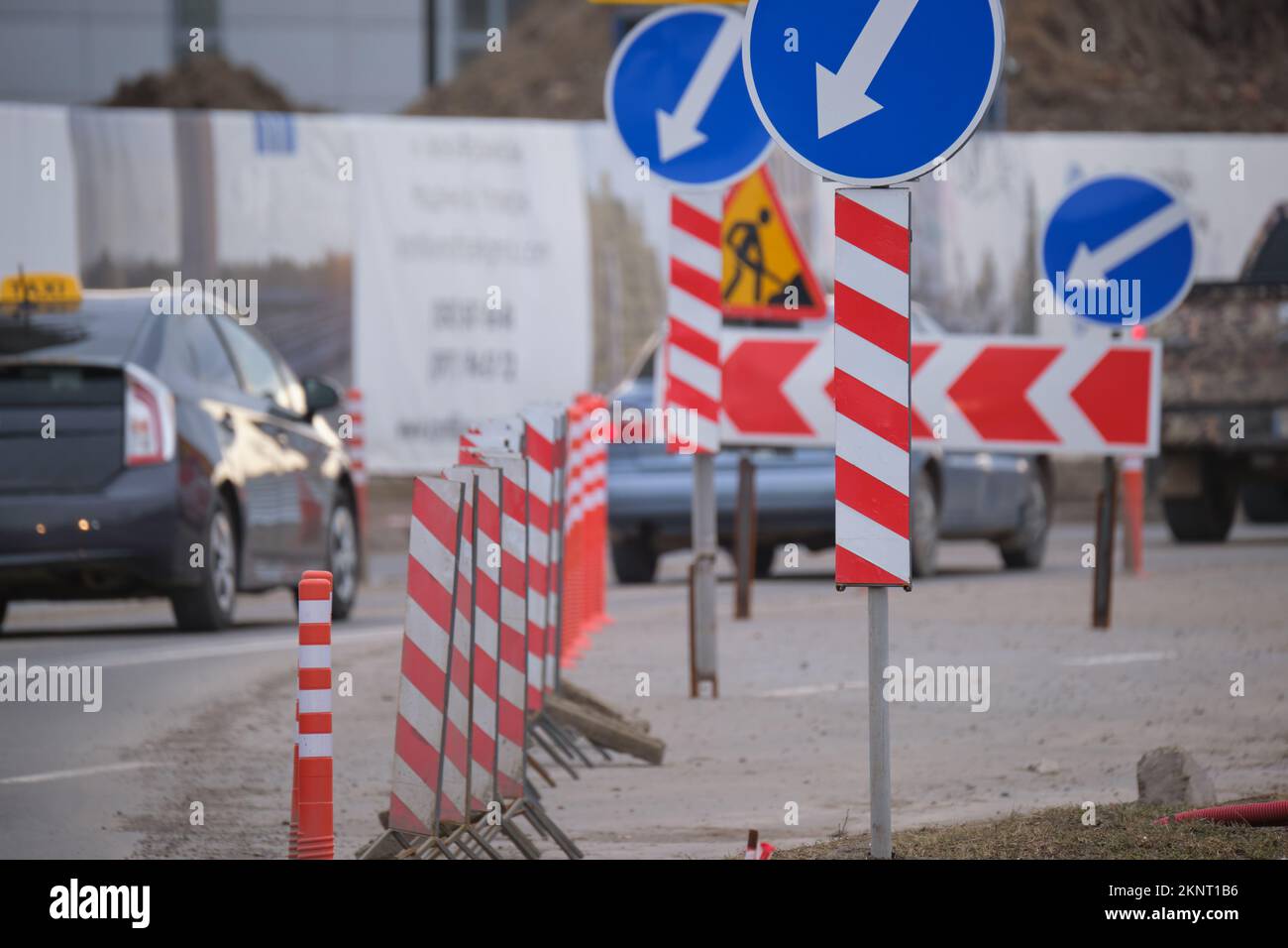 Roadworks warning traffic signs of construction work on city street and slowly moving cars Stock ...