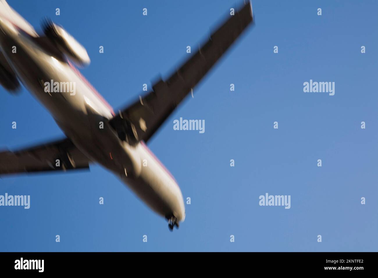 Underside view of a commercial jet airplane in flight with motion ...