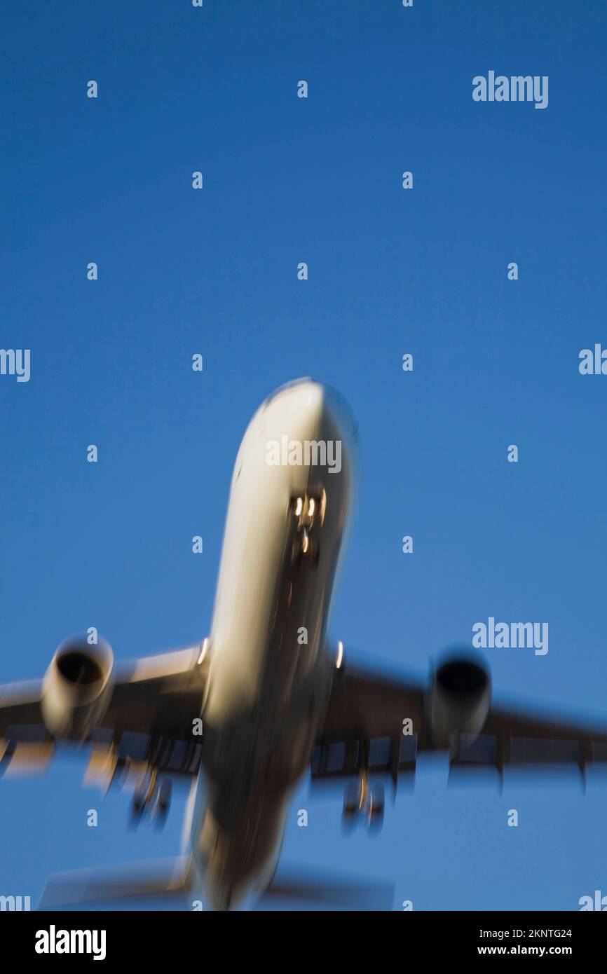 Underside view of a commercial jet airplane in flight with motion ...