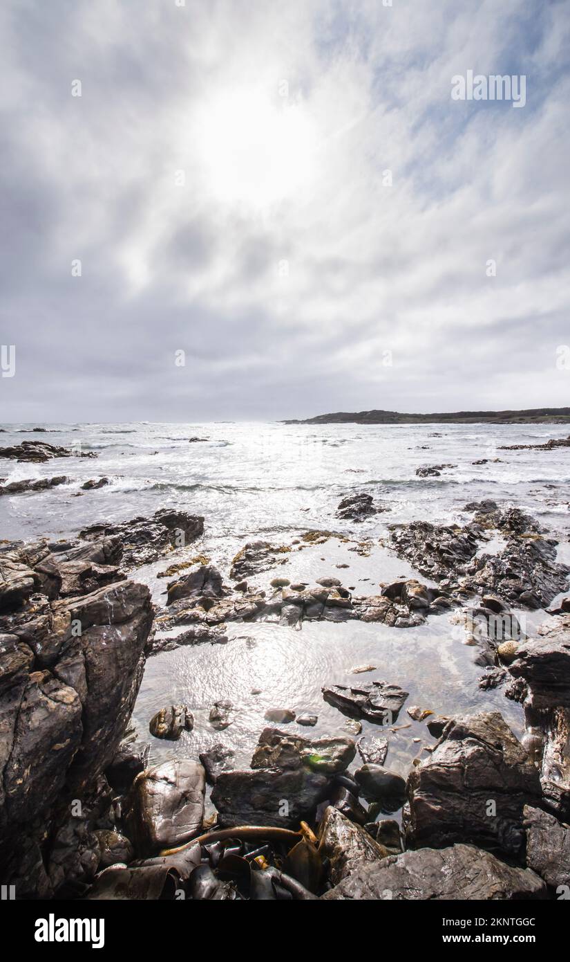 Dramatic sunset over a cloudy remote rocky seascape taken dusk ...