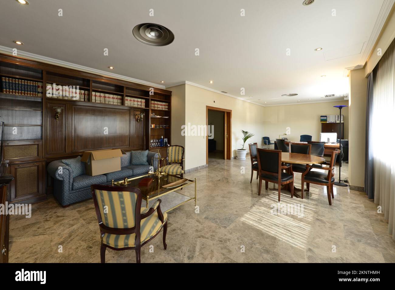 Office of professional office with dark wood bookcase and wooden tables ...