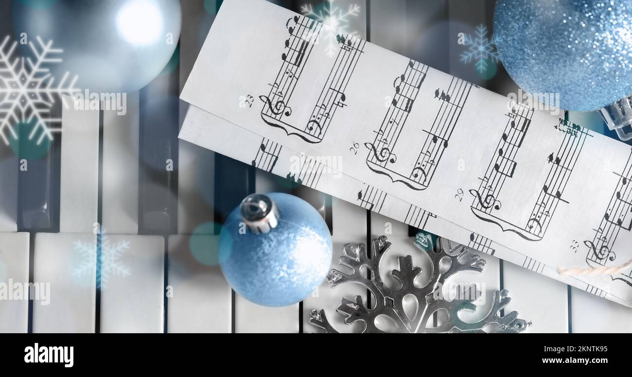 Christmas balls with music note sheets and snowflakes on piano keys ...