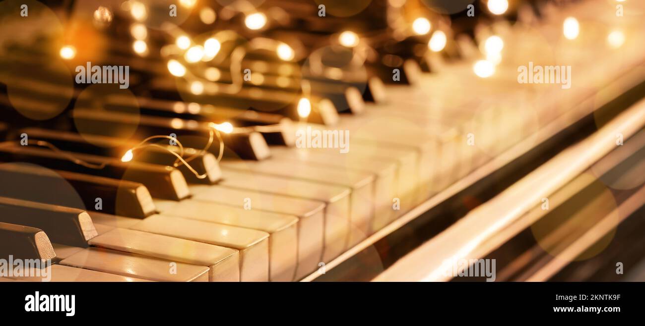 Piano keys with glowing Christmas lights, closeup Stock Photo - Alamy