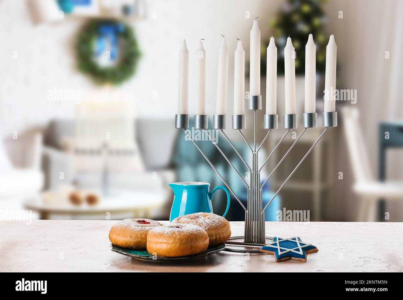 Menorah and donuts for Hanukkah on table in room Stock Photo - Alamy