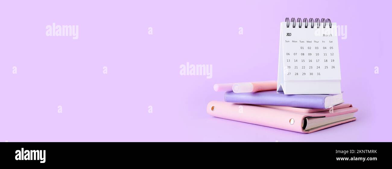 Flip paper calendar and notebooks on lilac background with space for ...