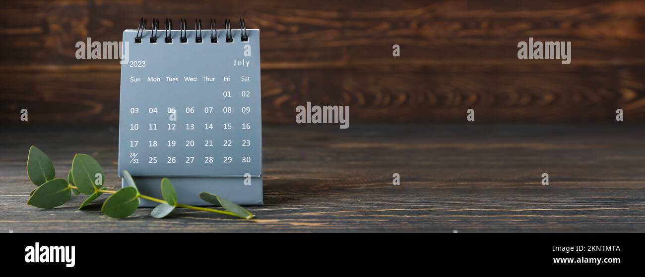 Flip paper calendar and eucalyptus branch on wooden background with ...