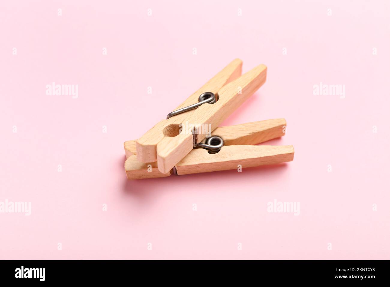 Two wooden clothespins on pink background Stock Photo - Alamy