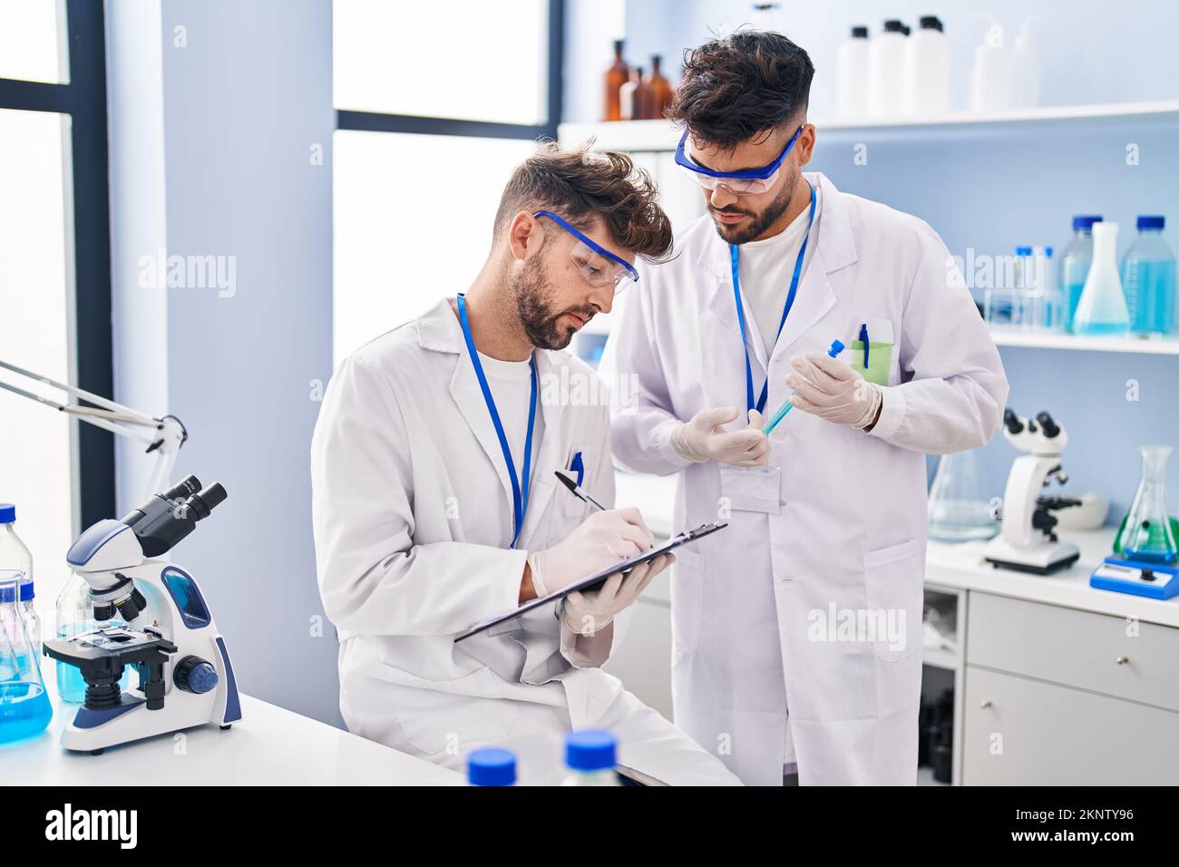 Young couple wearing scientist uniform working at laboratory Stock ...