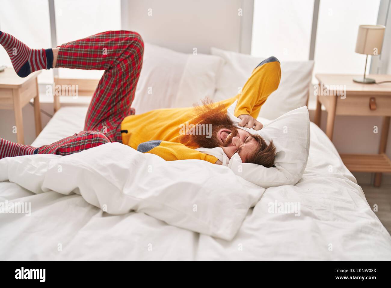 Young redhead man covering ears for noise at bedroom Stock Photo - Alamy