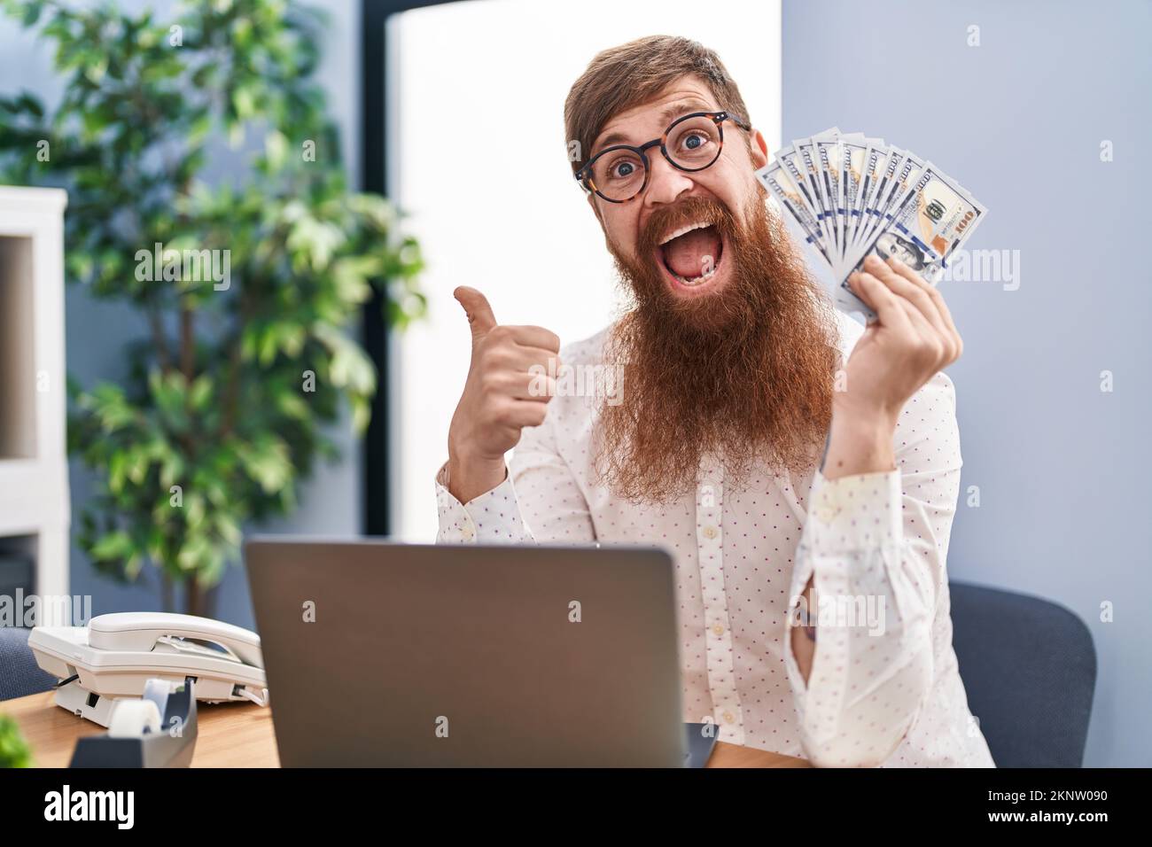 Caucasian man with long beard working using computer laptop holding ...