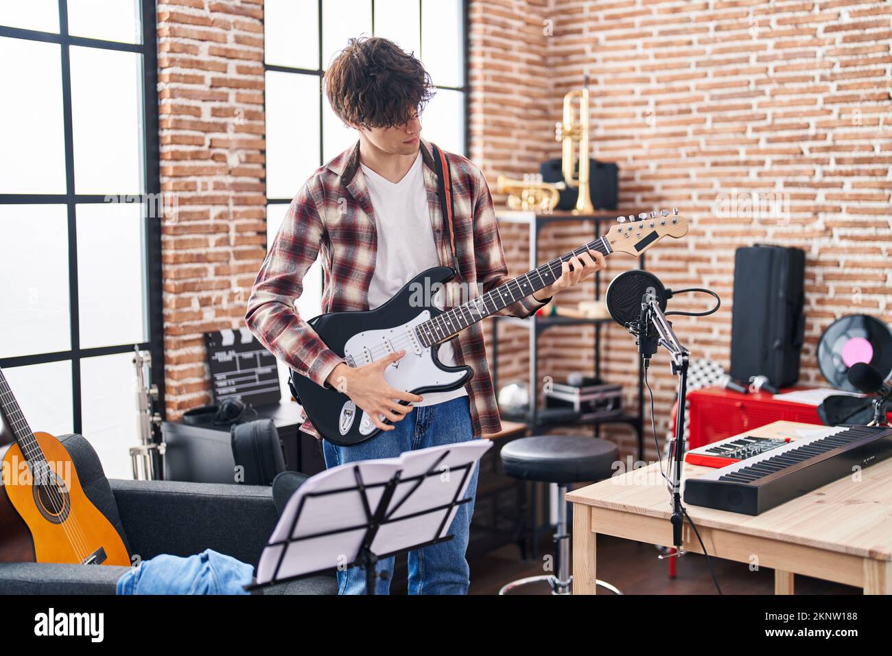 Young hispanic man musician playing electrical guitar at music studio ...