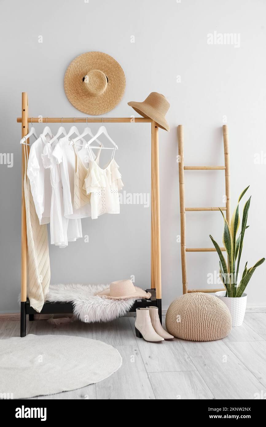 Interior of light dressing room with rack, clothes and ladder Stock ...