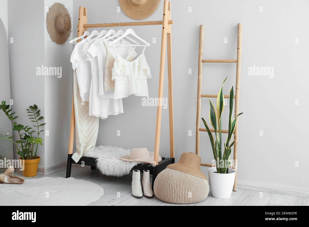 Interior of light dressing room with rack, clothes and ladder Stock ...