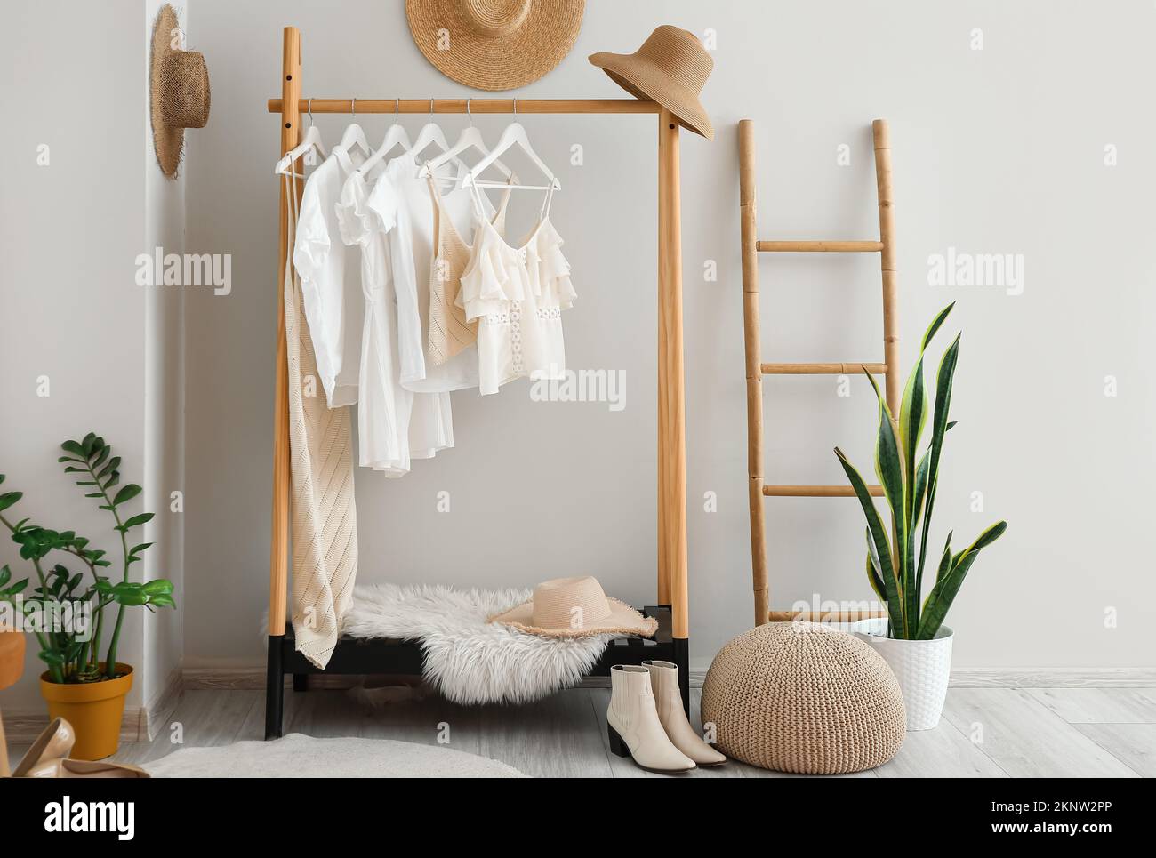 Interior of light dressing room with rack, clothes and ladder Stock ...