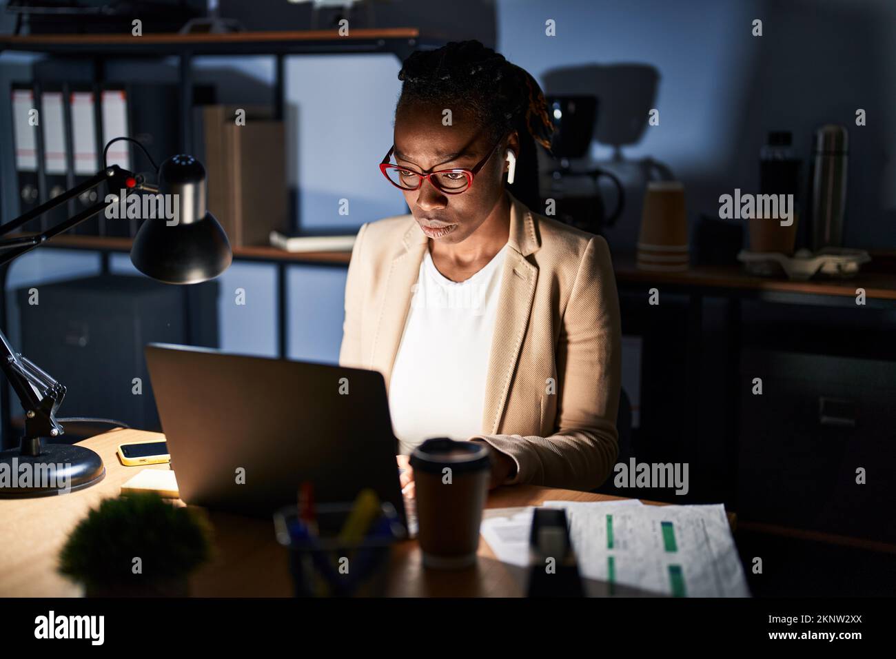 Beautiful black woman working at the office at night depressed and ...