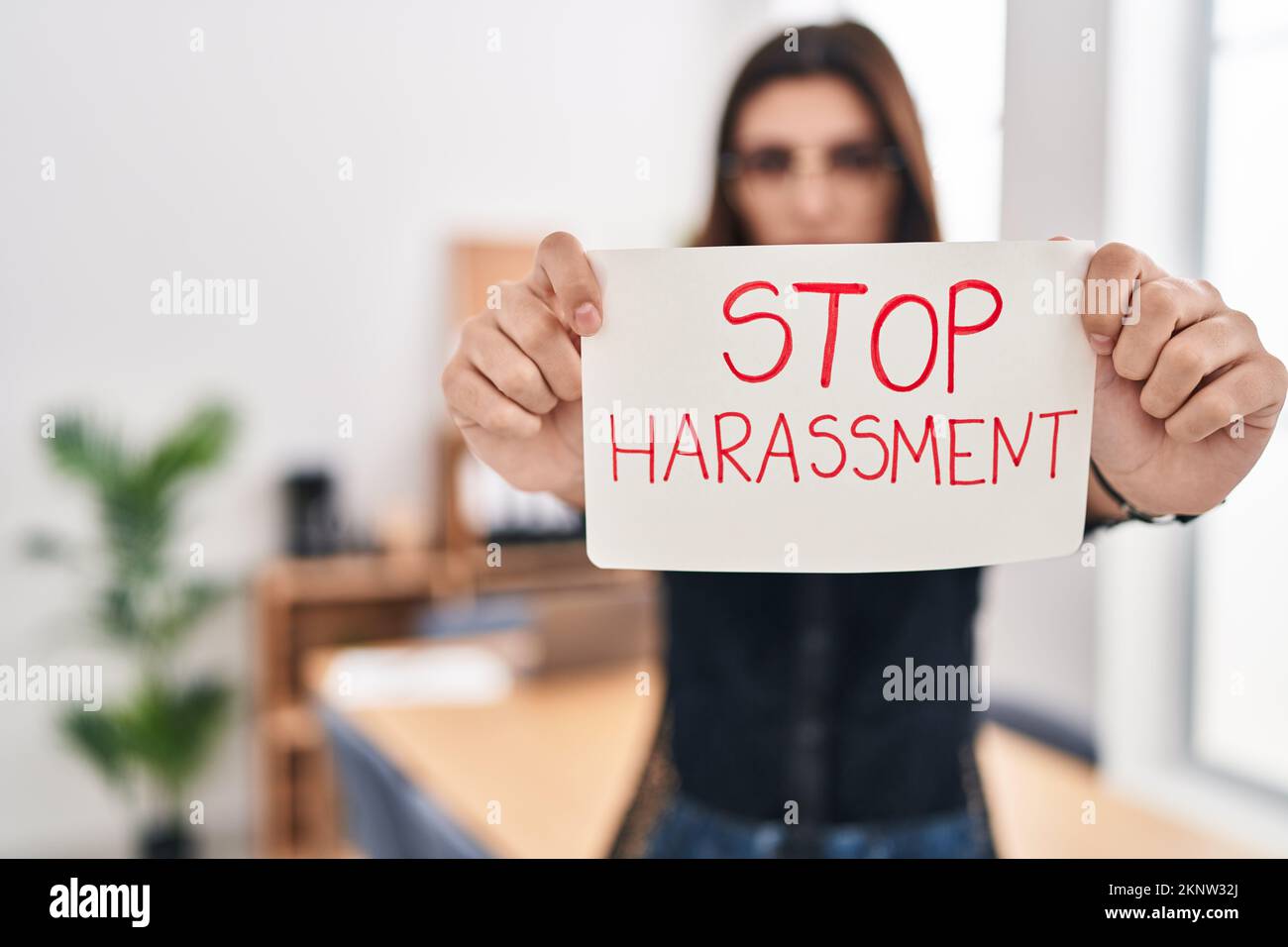 Young beautiful hispanic woman business worker holding stop harassment ...