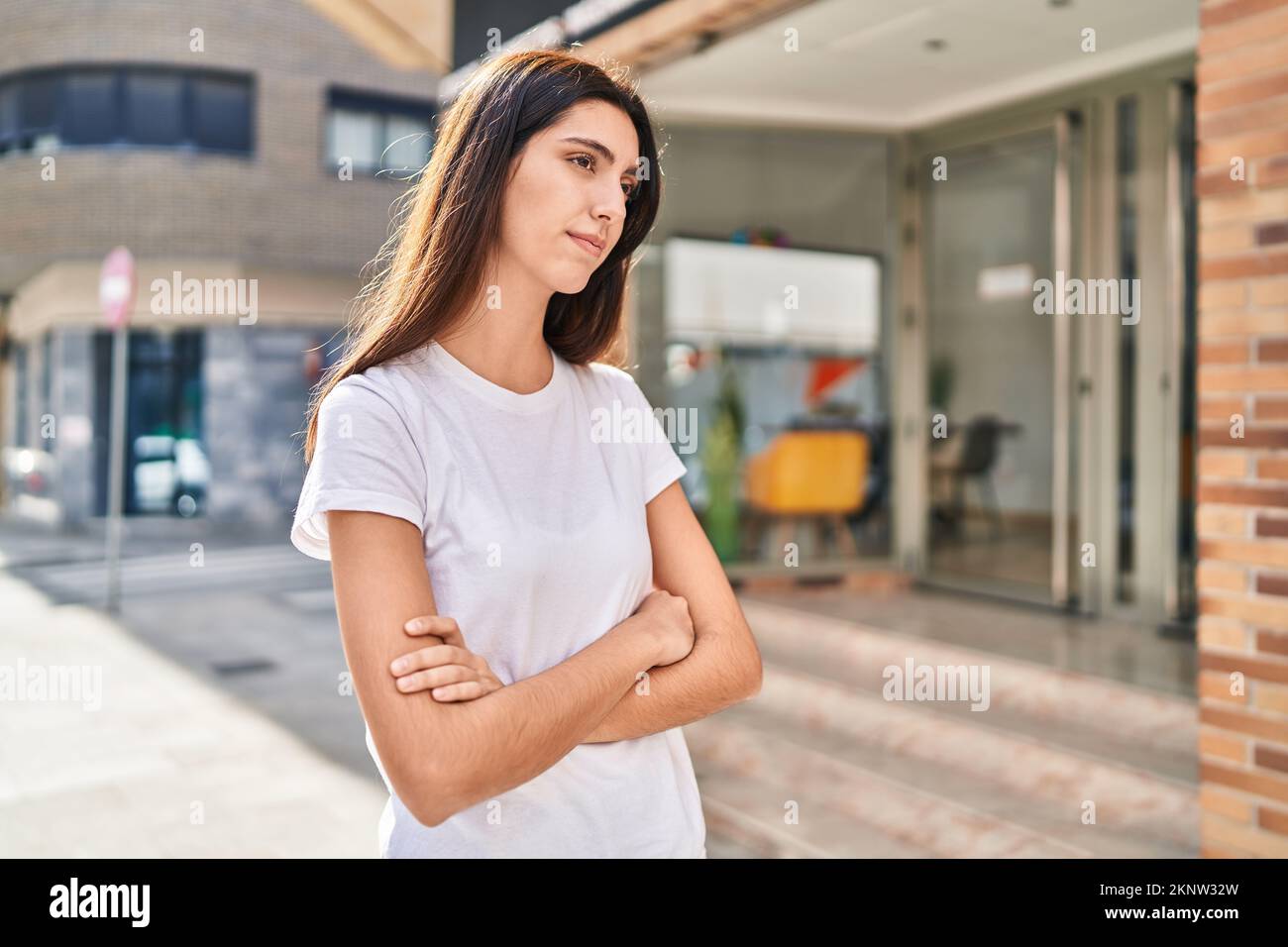 Young beautiful hispanic woman standing with serious expression and ...