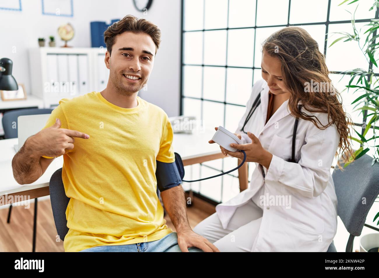Young doctor woman checking blood pressure on patient pointing finger ...