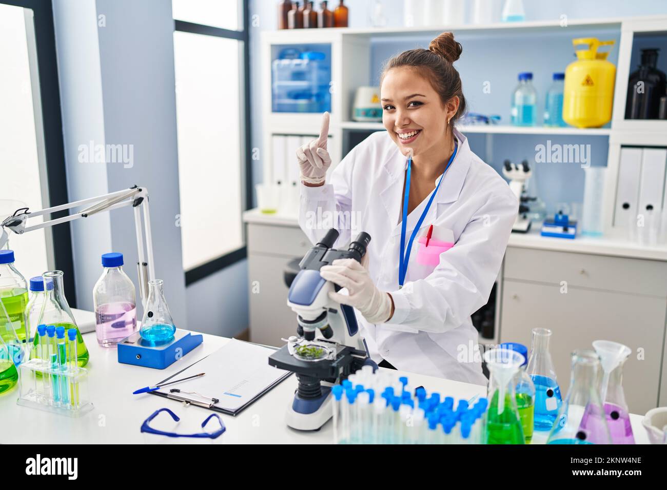 Young hispanic woman working at scientist laboratory surprised with an ...