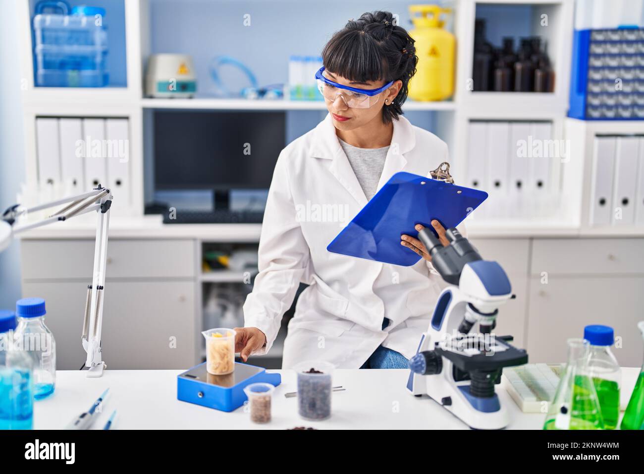 Young woman scientist measuring liquid at laboratory Stock Photo - Alamy