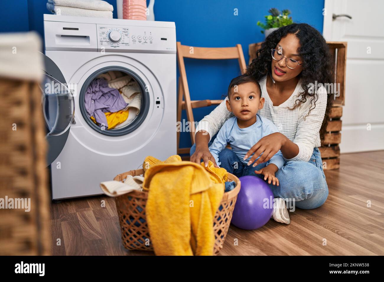 Mother and son smiling confident washing clothes at laundry room Stock ...