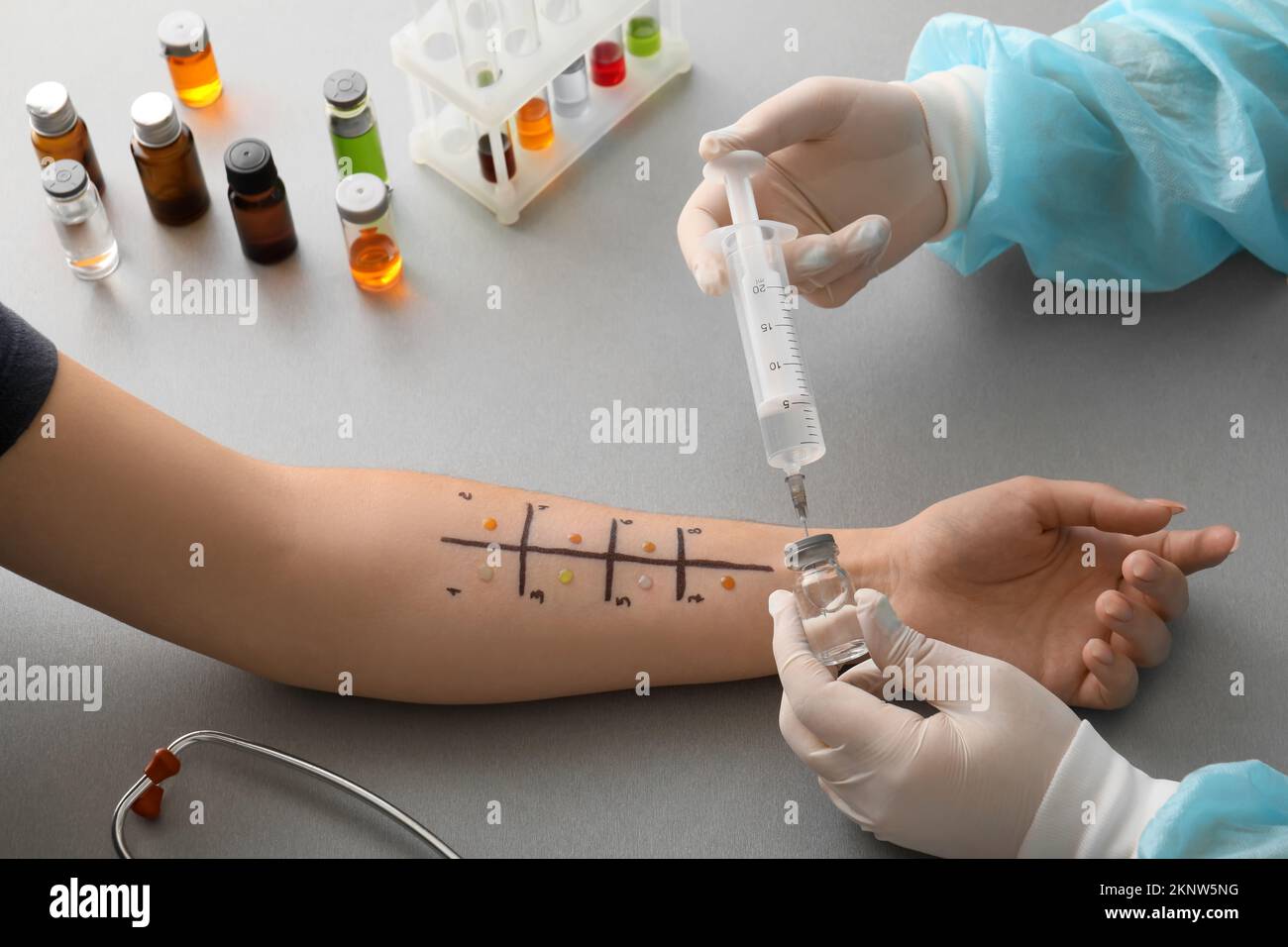 Doctor with syringe and ampule making allergy skin test to patient in ...