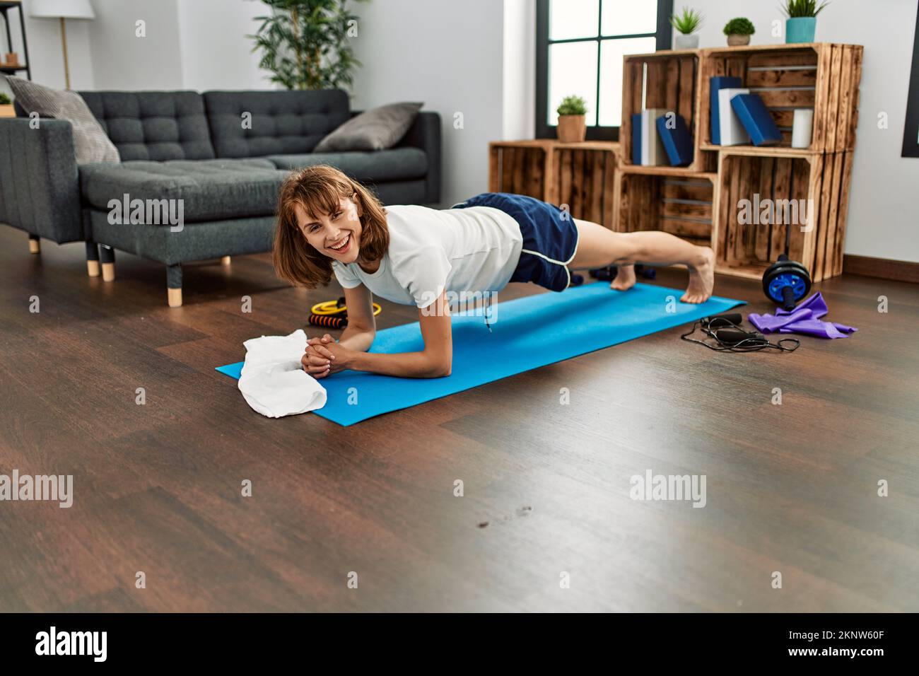 Young caucasian woman smiling confident training abs exercise at home ...