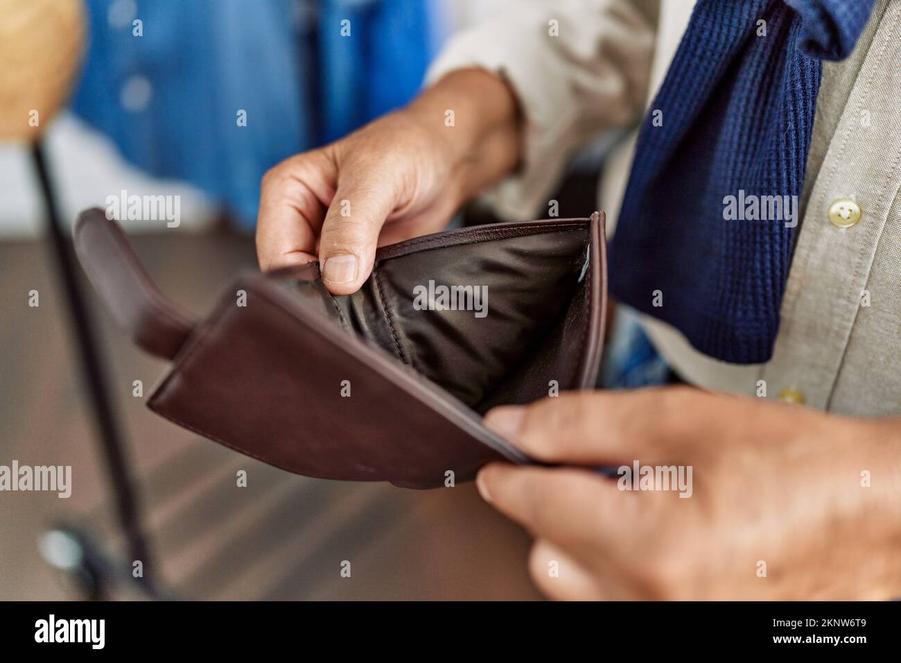 Senior grey-haired man showing empty wallet at clothing store Stock ...