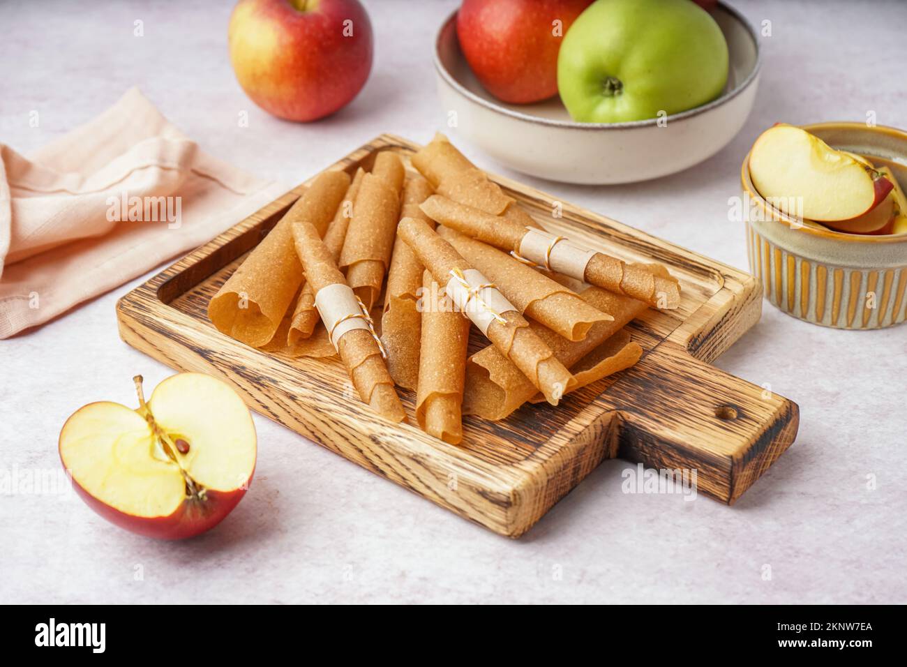 Wooden board with tasty apple pastilles on light background Stock Photo ...