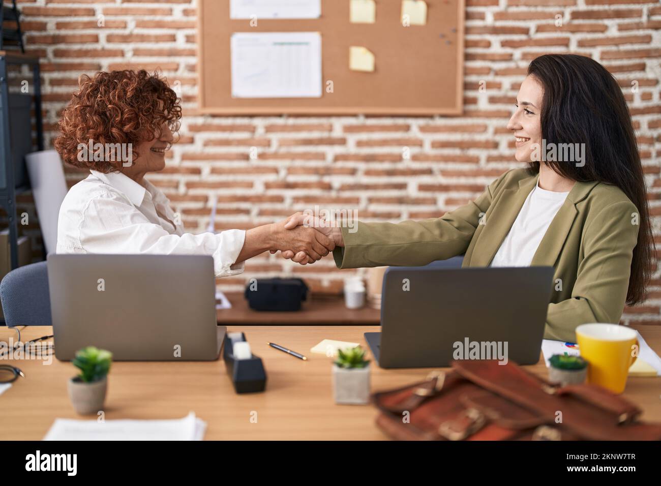 Two women business workers shake hands for agreement at office Stock ...