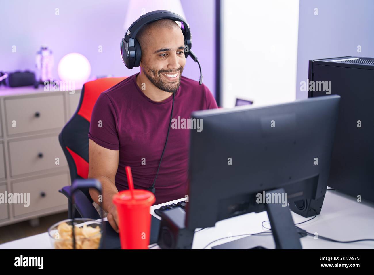 Young latin man streamer playing video game using computer at gaming ...