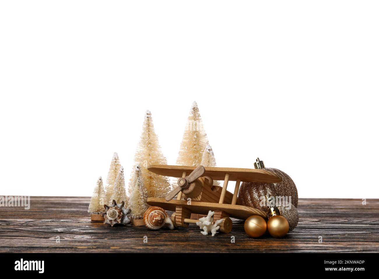 Wooden airplane with Christmas trees, balls and seashells on table ...