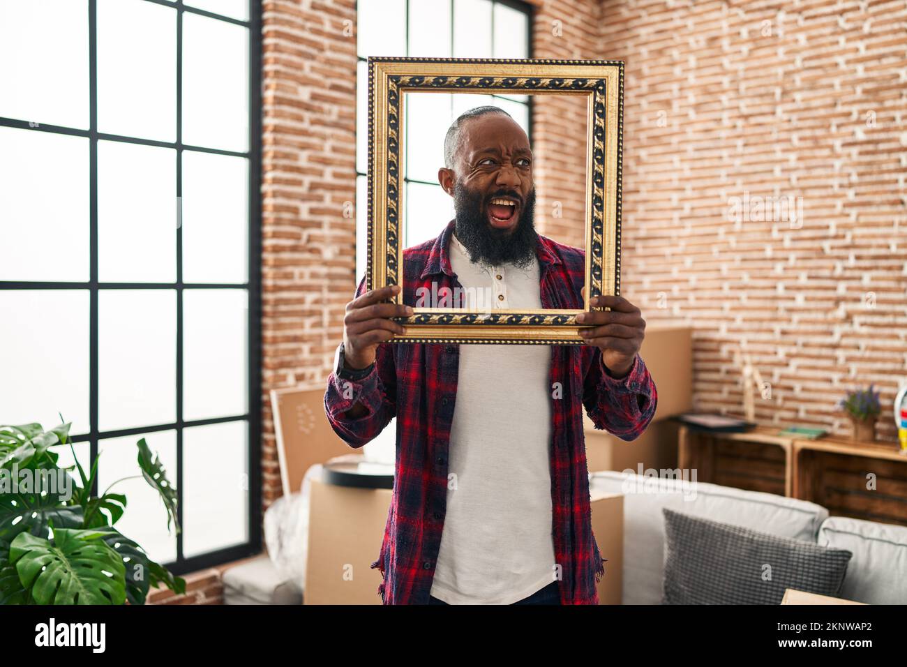 African american man putting face in empty frame angry and mad ...