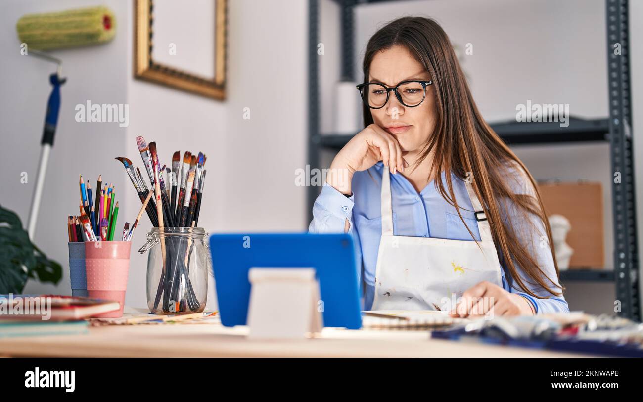 Young woman artist having video call drawing on notebook at art studio ...