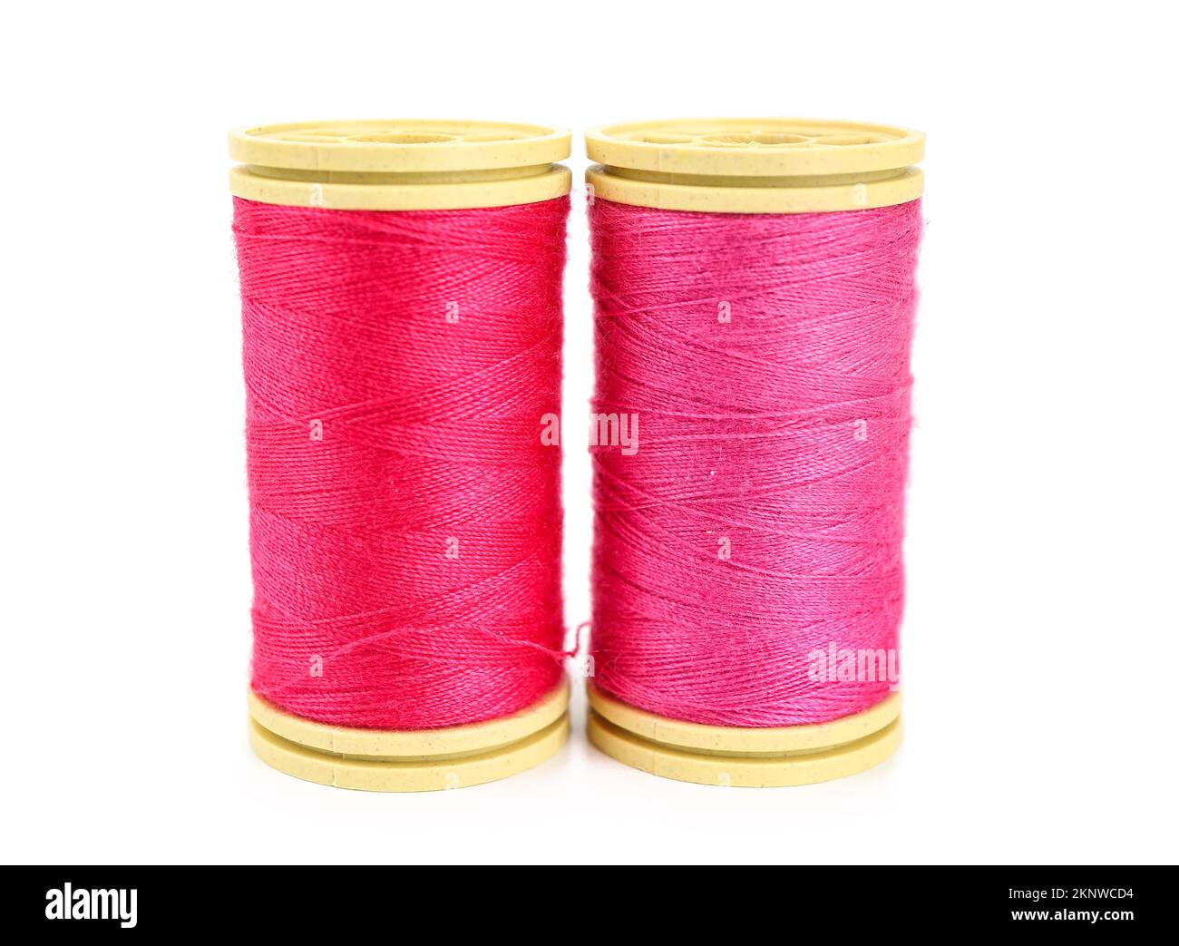 Pink thread spools on white background Stock Photo - Alamy