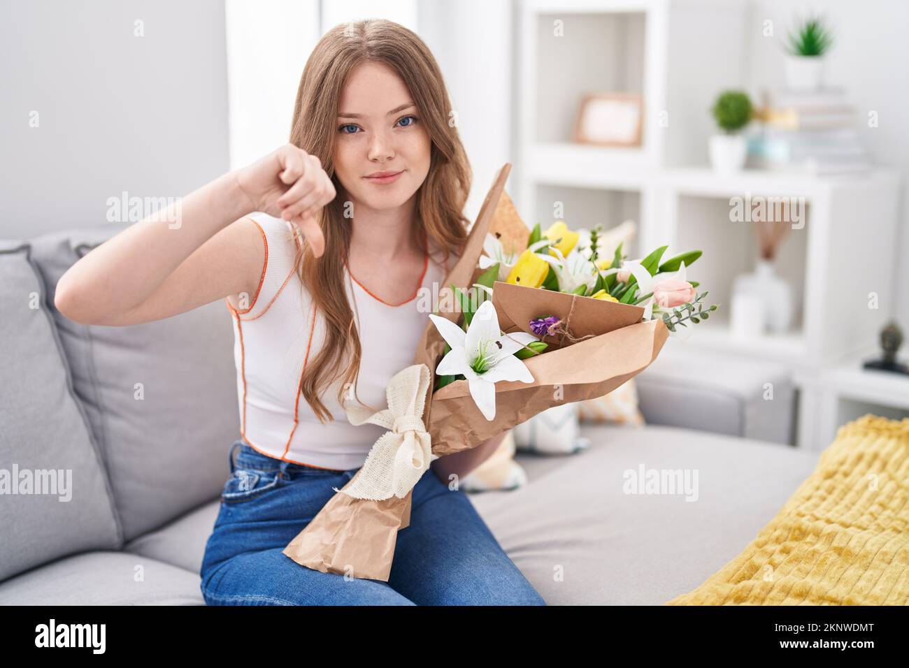Caucasian woman holding bouquet of white flowers with angry face ...