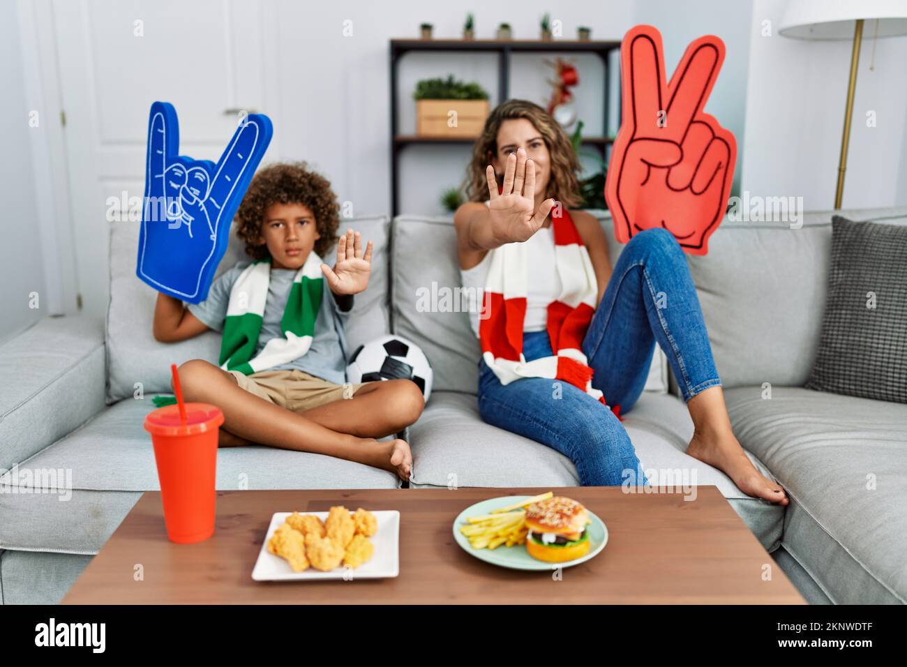 Young woman and son football hooligan cheering game with open hand ...